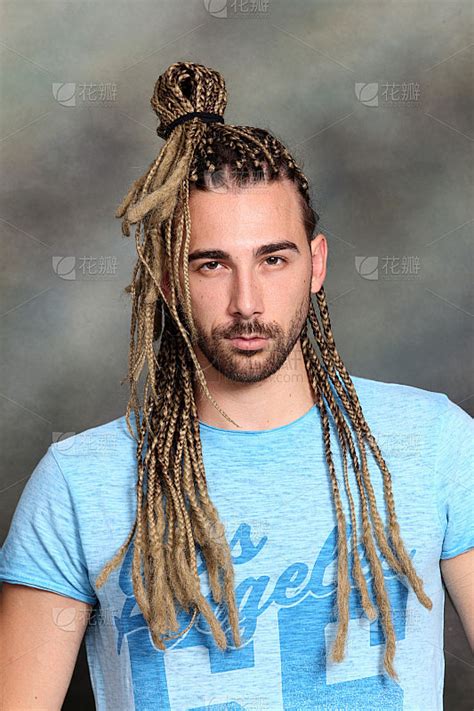 有吸引力的金发男性模型结合辫子和雷鬼发在孤立的背景在工作室摆姿势。 有吸引力的金发男性模型结合辫子和雷鬼发在孤立的背景在工作室摆姿势。