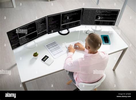 Computer Programmer Writing Program Code On Computer In Office Stock