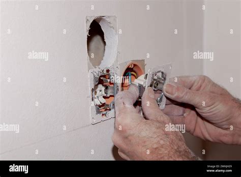 Hand Of Electrician Installing A Wall Socket Electrician Replacing A