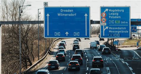 자동차는 머리 위에 도로 표지판이 있는 고속도로를 주행합니다 사진 Unsplash의 자동차 이미지