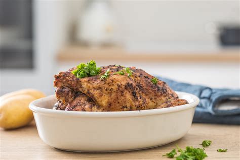 흰 접시에 구운 통 닭고기와 생 감자를 키치 테이블에 올려놓았다 배경의 홈 인테리어 0명에 대한 스톡 사진 및 기타 이미지 0명 가금류 가정 주방 Istock