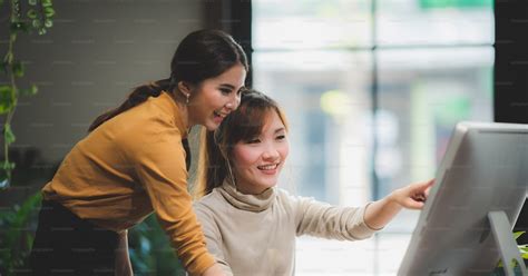 도서관에서 즐겁게 공부하는 국제 대학생 그룹 현대적인 공동 작업 공간의 두 동료가 컴퓨터로 책상 테이블에 앉아 이야기하고 웃고 있습니다 사진 Unsplash의 앉아 이미지