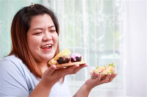 Asian Fat Woman Eating Delicious Chocolate Dessert In Hand Stock Image