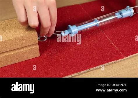 A Hand Uses A Spring Scale To Measure Friction On A Wooden Block Over