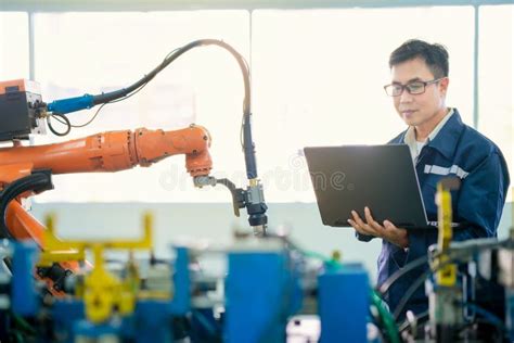 Automation Concept Asian Senior Robot Training Engineer Is Holding Laptop And Monitoring To
