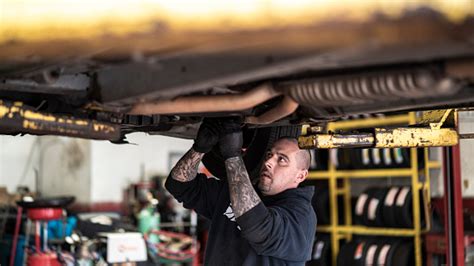 수리공 자동차 정비사 손에 문신을 가진 백인 백인 남자 자동차 수리점에서 작업 리프트에 상승 된 자동차의 서스펜션을 고정 검사 보기에 대한 스톡 사진 및 기타 이미지