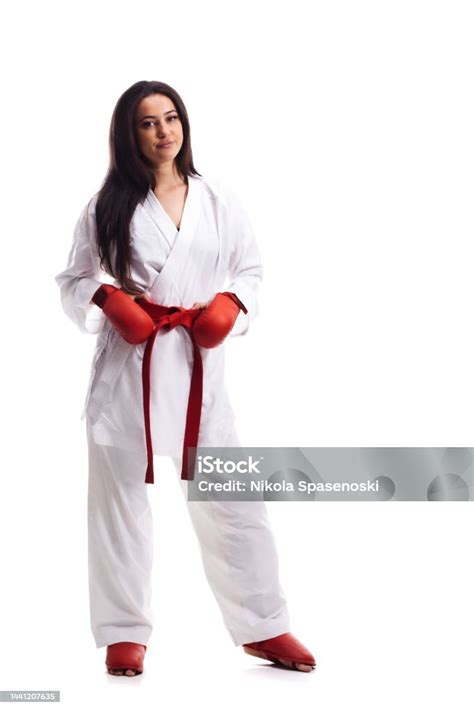 Girl Wearing Kimono And Red Gloves Exercising Karate Against White