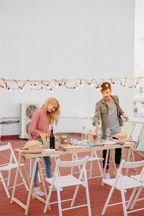 Couple Arranging Table For Party by Stocksy Contributor Javier Díez Stocksy