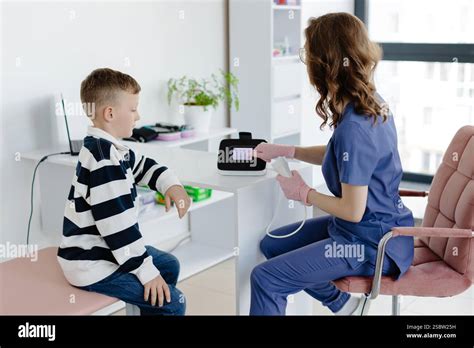 Boy Testing Breathing Function By Spirometry In Doctors Office