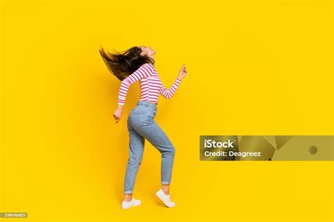 긍정적 인 여자 친구 트렌디 한 줄무늬 의상의 전체 길이 프로필 측면 사진은 노란색 배경에 고립 된 빈 공간을 편안하게 휴식을 취합니다 30 34세에 대한 스톡 사진 및