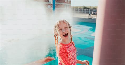 귀여운 사랑스러운 웃음 백인 웃기는 여자는 여름날 야외 스플래시 패드 놀이터에서 놀고 있습니다 아이들을 위한 계절별 수상 스포츠 레크리에이션 활동 사진