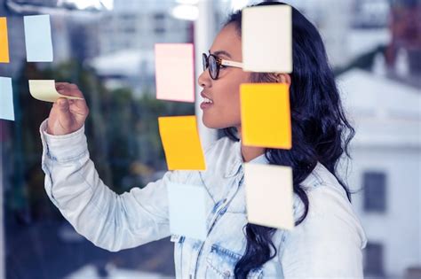 Premium Photo Asian Woman Removing Sticky Note By Glass Wall