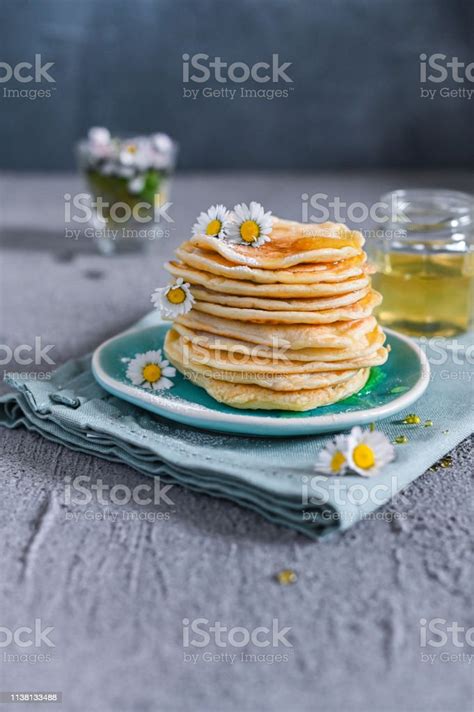 꿀 이나 시럽 많은 작은 팬케이크 맛 있는 전통 아침 식사 사진에서 음식 스타일링으로 봄 꽃 회색 돌 배경과 디저트는 달 콤 합니다 테스트를 위한 여유 공간 0명에 대한
