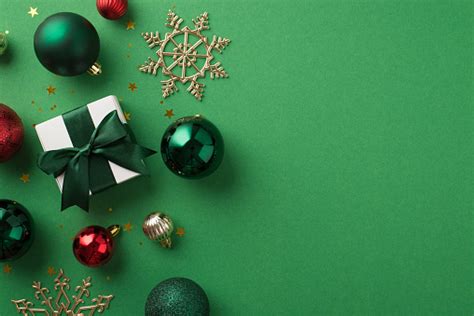 녹색 활 별 모양의 색종이와 빈 공간이있는 고립 된 녹색 배경에 스팽글과 크리스마스 장식 녹색 빨간색과 실버 볼 황금 눈송이 흰색 선물 상자의 상단 보기 사진 12월에 대한