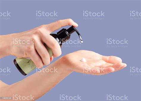 모이스처라이저 스킨케어 그리고 스튜디오의 파란색 배경에 분리된 크림 한 병을 들고 있는 손 미용 화장품 및 수분 치료 및 손질을