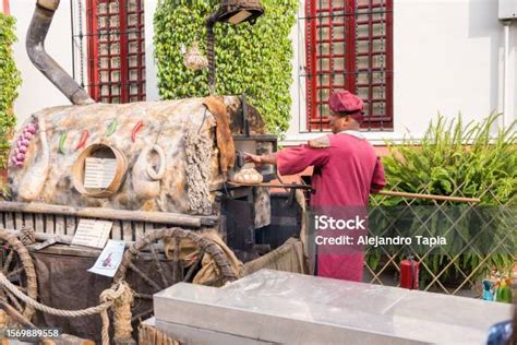장작불 오븐에서 빵을 만드는 남자 전통 음식 박람회에서 제빵사 한 남자가 오븐에서 집에서 만든 둥근 빵 한 덩어리를 꺼냅니다