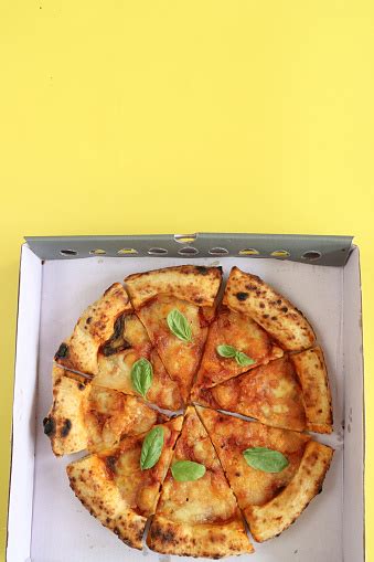 골판지 테이크 아웃 피자 상자에 얇게 썬 피자 마르게리타 녹인 황금 버팔로 모짜렐라 치즈와 풍부한 토마토 마리 나라 소스 토핑 노란색 배경 복사 공간 이미지 0명에 대한