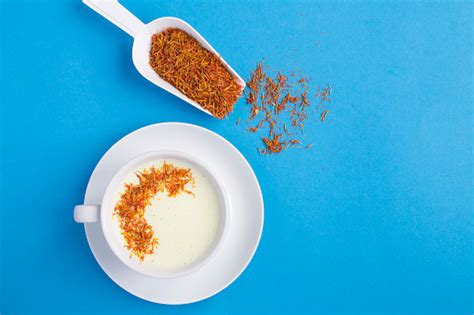파란색 배경의 흰색 컵에 사프란 라떼 또는 사프란 달 우유의 최고 보기 사프란에 대한 스톡 사진 및 기타 이미지 사프란 0명 건강한 식생활 Istock