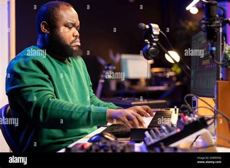 African American Audio Technician Using Piano Synthesizer Keys To Add