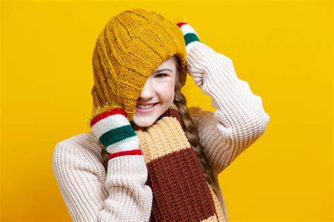 겨울 개념 따뜻한 니트 모자와 스카프를 들고 노란 얼굴을 한 채 포즈를 취하는 코카서스 블론드 소녀를 외치는 윈섬의 초상화 14