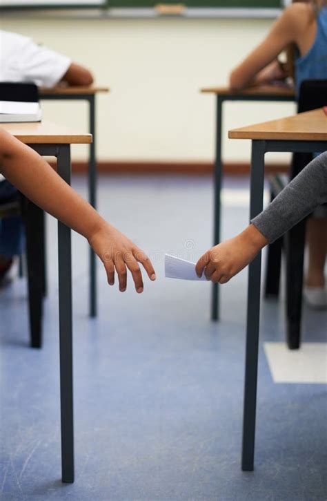 Passing A Note Two Students Passing Notes During Class Stock Image