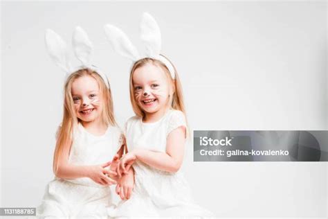 토끼 귀 흰색 드레스에 작은 금발 쌍둥이 회색 배경에 스튜디오 사진 아 이들은 부활절을 축 하 합니다 2 3 살에 대한 스톡