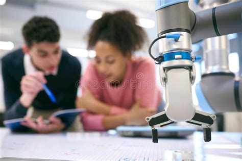 Male And Female College Or University Engineering Babes In Robotics Class Working On Robot