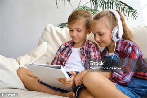 Kakak Dan Adik Yang Lucu Menikmati Tablet Di Rumah Foto Stok Unduh
