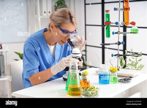 Happy Female Scientist With Flasks Of Samples And Microscope Testing Happy Female Scientist With Flasks Of Samples And Microscope Testing