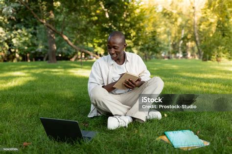 시험 학습 개념 흑인 남자 학생 남자는 노트북에서 온라인 수업을보고 공원의 잔디밭에 앉아있는 동안 메모를합니다 계획에 대한 스톡 사진 및 기타 이미지 Istock