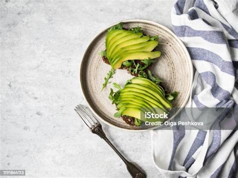 회색 배경의 호밀 곡물 빵에 아루굴라와 아보카도를 곁들인 건강한 홈메이드 토스트 맨 위 보기 0명에 대한 스톡 사진 및 기타 이미지 Istock