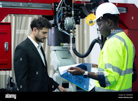 Technicians Are Introducing Industrial Hand Robots To Businessperson Of