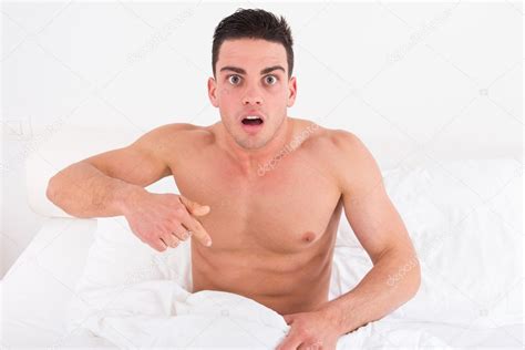 Half Naked Young Man In Bed Looking Down At His Underwear At Hi Stock