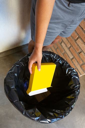 검은 가방 쓰레기통에 종이 골판지 상자를 던지는 여자의 손을 닫습니다 개념을 재활용 재사용 및 줄입니다 지구를 저장하고 오염과 폐기물을 줄일 수 있습니다 집에서 캐주얼 한