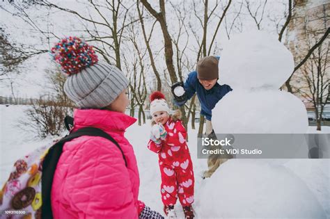 젊은 가족 남자 여자 만들기 눈싸움 눈사람 설 공원이 나 숲 야외에서 따뜻한 옷 플레이 어린 소녀 겨울 재미 휴일에 여 가입니다 사랑 관계 가족 사람들 라이프 스타일