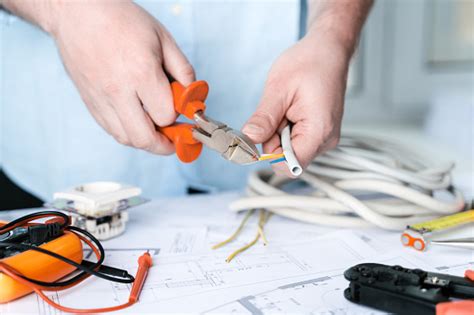 남자 집에서 전기 프로젝트를 만드는 수리공 수리 계획 도면 다이어그램 아파트 건물의 전기화 계획 장치 액세서리 전압계 전선 스크루 드라이버 펜치 테이프 측정 3차원 형태에