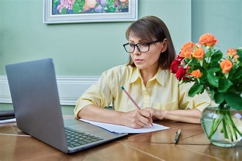 노트북을 사용하여 책상에서 집에서 일하는 중년 비즈니스 여성 40 49세에 대한 스톡 사진 및 기타 이미지 40 49세 45 49세 가정 생활 Istock