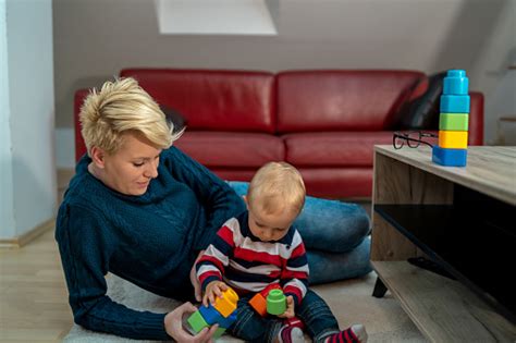 귀여운 작은 아기 소년 만들기 그의 첫 번째 단계 흰색 거실에서 그의 어머니에 게 산책 가구에 대한 스톡 사진 및 기타 이미지