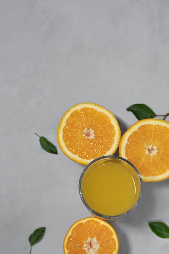 오렌지 주스를 유리에 넣고 회색 배경에 잎이 있는 오렌지 의 세 반쪽 옆에 있습니다 공간을 복사합니다 위에서 볼 수 있습니다 0명에 대한 스톡 사진 및 기타 이미지 Istock