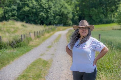 Mature Woman Standing On Country Path Between Dutch Farmland Stock