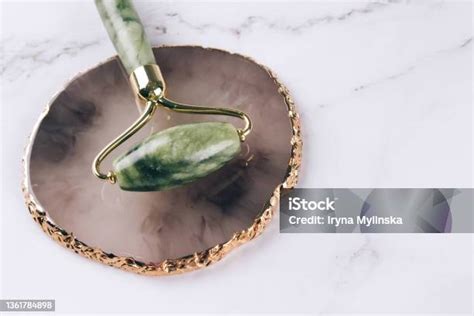 흰색 대리석 테이블 배경에 비취 얼굴 롤러와 구아 샤 도구의 가까이보기 천연 돌로 만든 리프팅 마사지 요법을 위한 페이셜 마사지