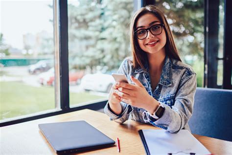 현대 스마트폰 카메라에 웃 고 하는 동안 무료 4 G 인터넷 연결을 사용 하 여 친구와 함께 온라인 채팅 광 안경에서 세련 된 아름 다운 젊은 여자의 반 길이 초상화 공부에