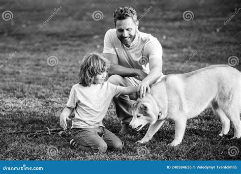 Padre E Hijo Jugando Con Perro En El Parque De Primavera Concepto De Familia Amigable Con
