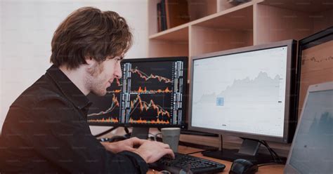 사무실에서 스트레스가 많은 하루 창조적 인 사무실에서 책상에 앉아있는 동안 얼굴에 손을 잡고있는 젊은 사업가 증권 거래소 거래 외환 금융 그래픽 개념입니다 사진