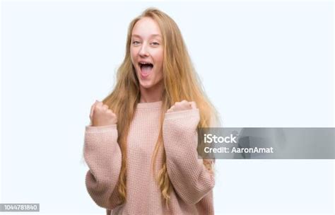 축 하 하는 분홍색 스웨터를 입고 금발 십 대 여자 놀라게 하 고 제기 하는 무기와 성공을 위한 놀라게 했 고 눈 우승자 개념입니다 겨울에 대한 스톡 사진 및 기타 이미지