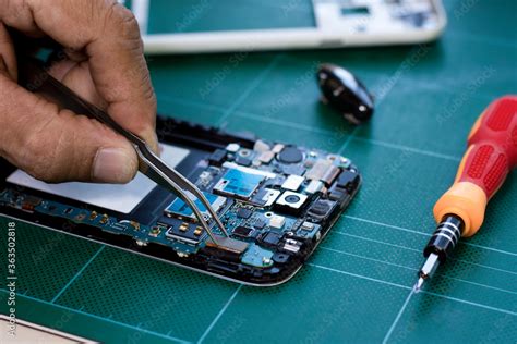 Technician Man Hand Repairing And Assembling The Motherboard Of Mobile Technician Man Hand Repairing And Assembling The Motherboard Of Mobile