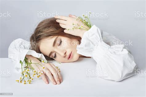 곱슬 금발 낭만적 인 모습 아름 다운 눈 손에 흰 야생화 소녀 흰 빛 드레스와 곱슬 머리 흰색 배경 순도와 무죄에 꽃을 가진 여자의 초상화 가정 생활에 대한 스톡 사진 및