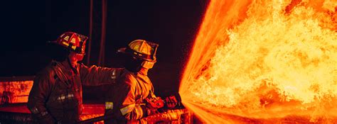 물과 소화기로 불길과 싸우는 용감한 소방관들 팀워크와 용기로 화재를 진압하는 소방관 강도 높은 소방 훈련 2명에 대한 스톡 사진 및 기타 이미지 Istock