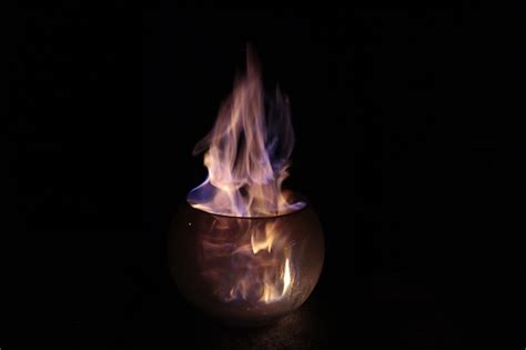 Premium Photo Close Up Of Fire In Container Against Black Background