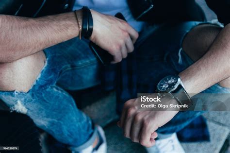 남자는 시간을 확인합니다 비정형된 청바지와 검은 자 켓 거리 스타일 시계 남자의 손입니다 반면에 스마트폰 보유 하 고 가죽에 대한 스톡 사진 및 기타 이미지 Istock
